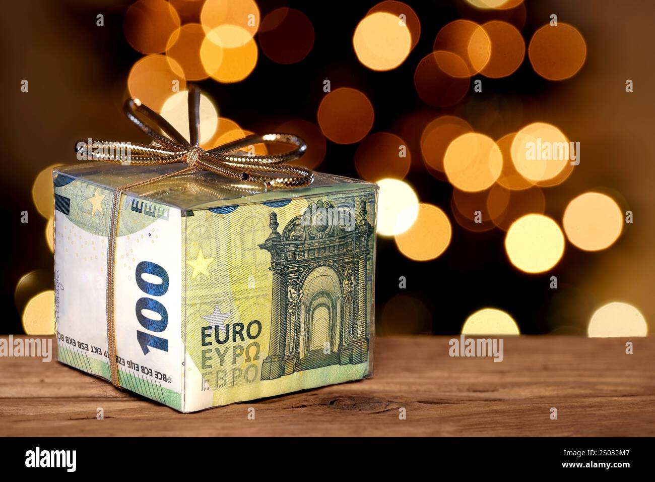 One hundred euro banknotes in transparent gift box with golden bow in ...