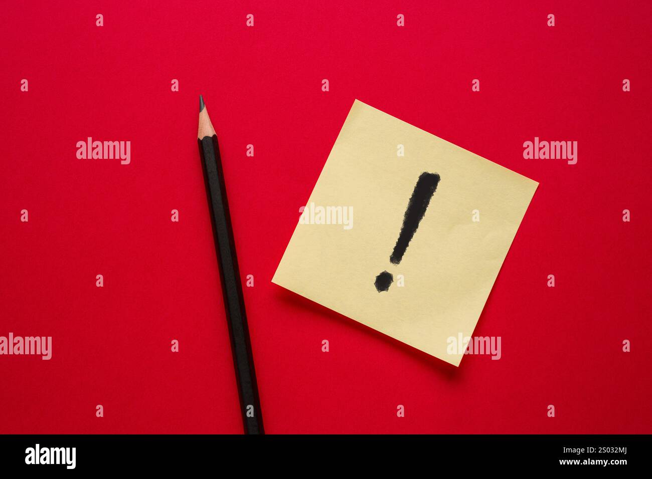 Exclamation mark written on a sticky note with a pen next to it on a ...