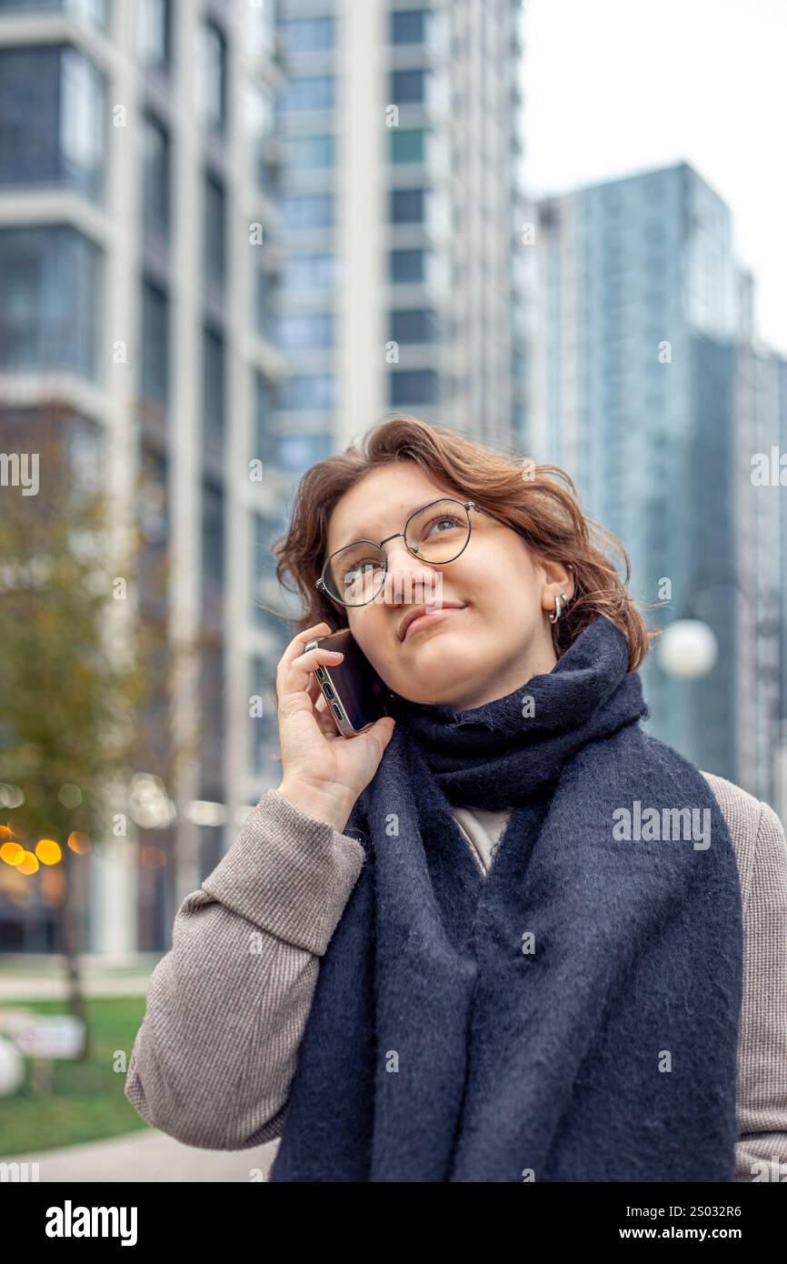 Cute teenage girl talking on the phone on the street. Girl in the city ...