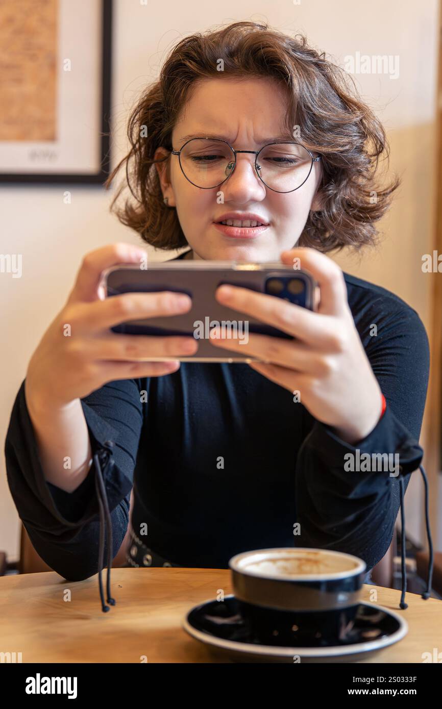 Angry teenage girl playing games on the phone. Emotions concept Stock ...