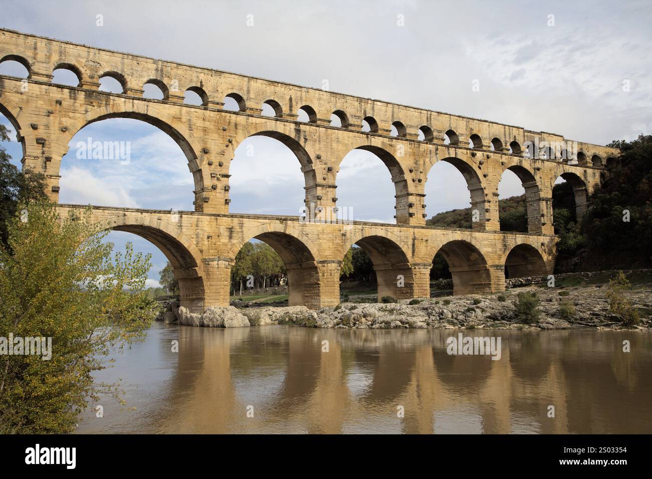 Visitors admire the impressive Roman aqueduct bridge in a scenic ...