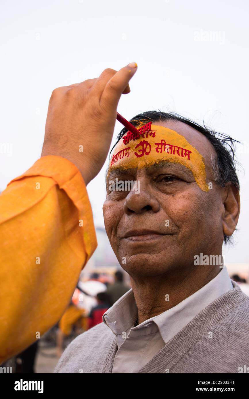 A pilgrim gets “om Sita Ram” tilaka (forehead marking) at Ram ...