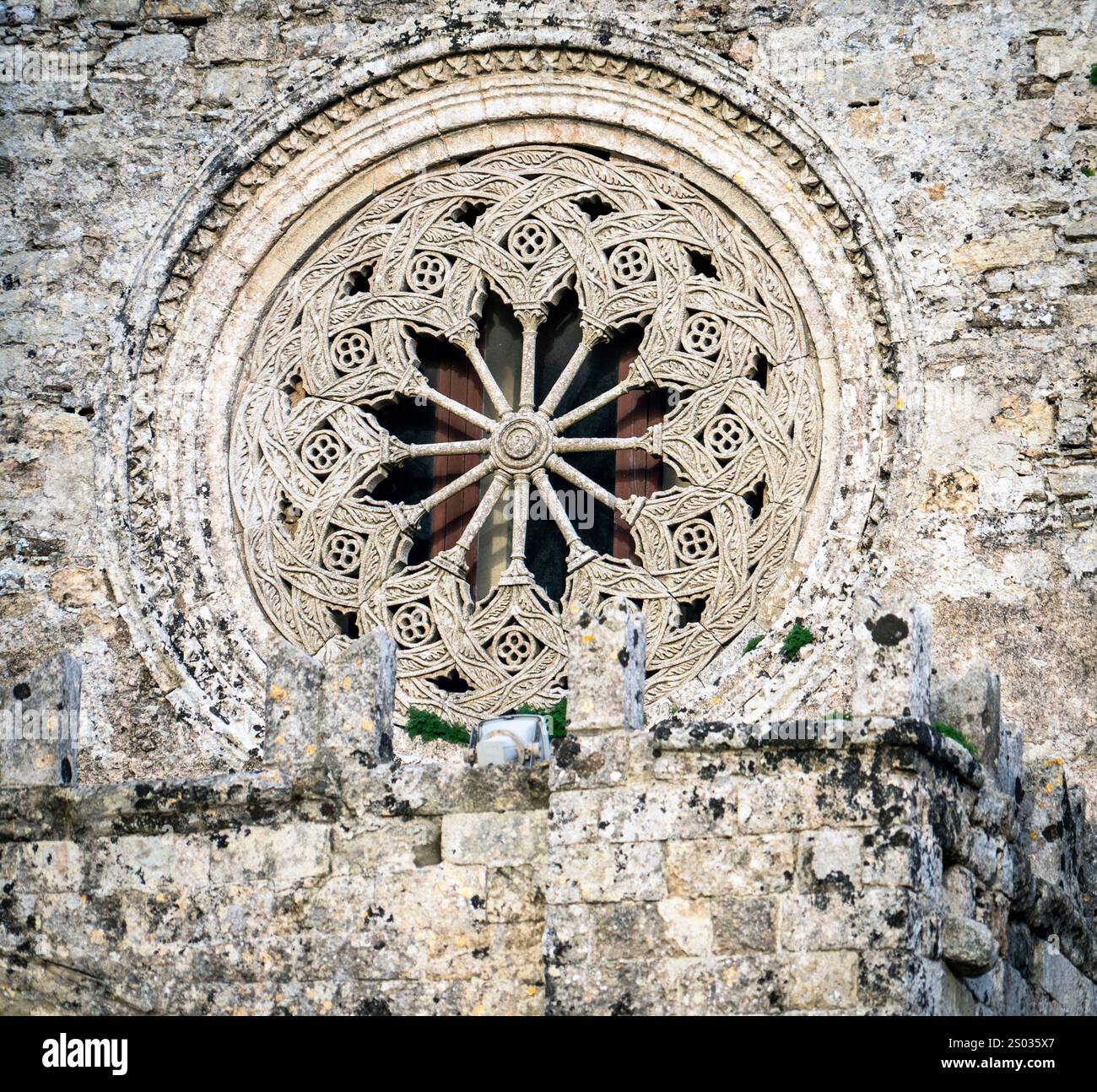 A detailed stone window with intricate carvings, featuring a circular ...