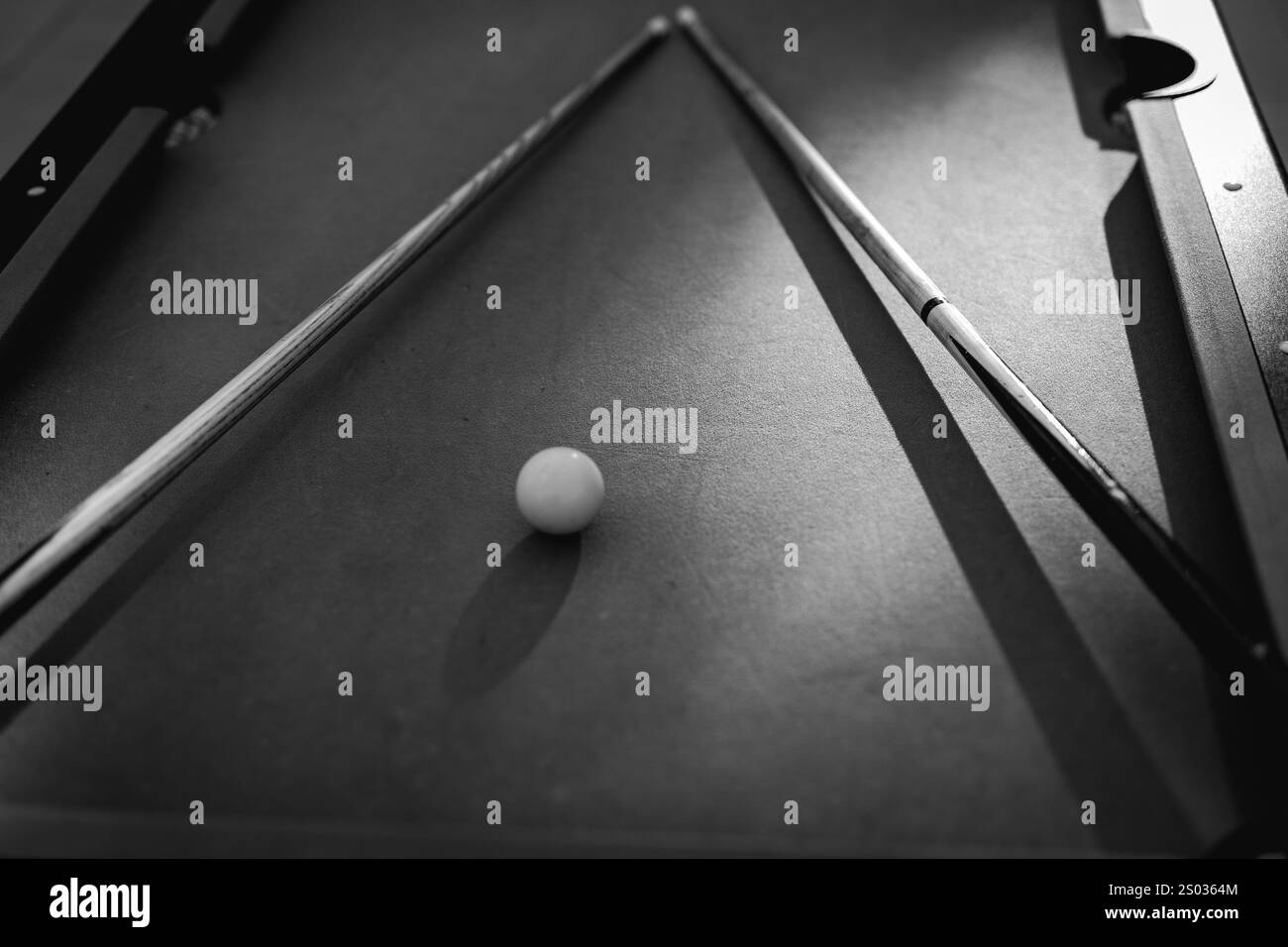 A pool table with scattered billiard balls, a cue stick, and ...