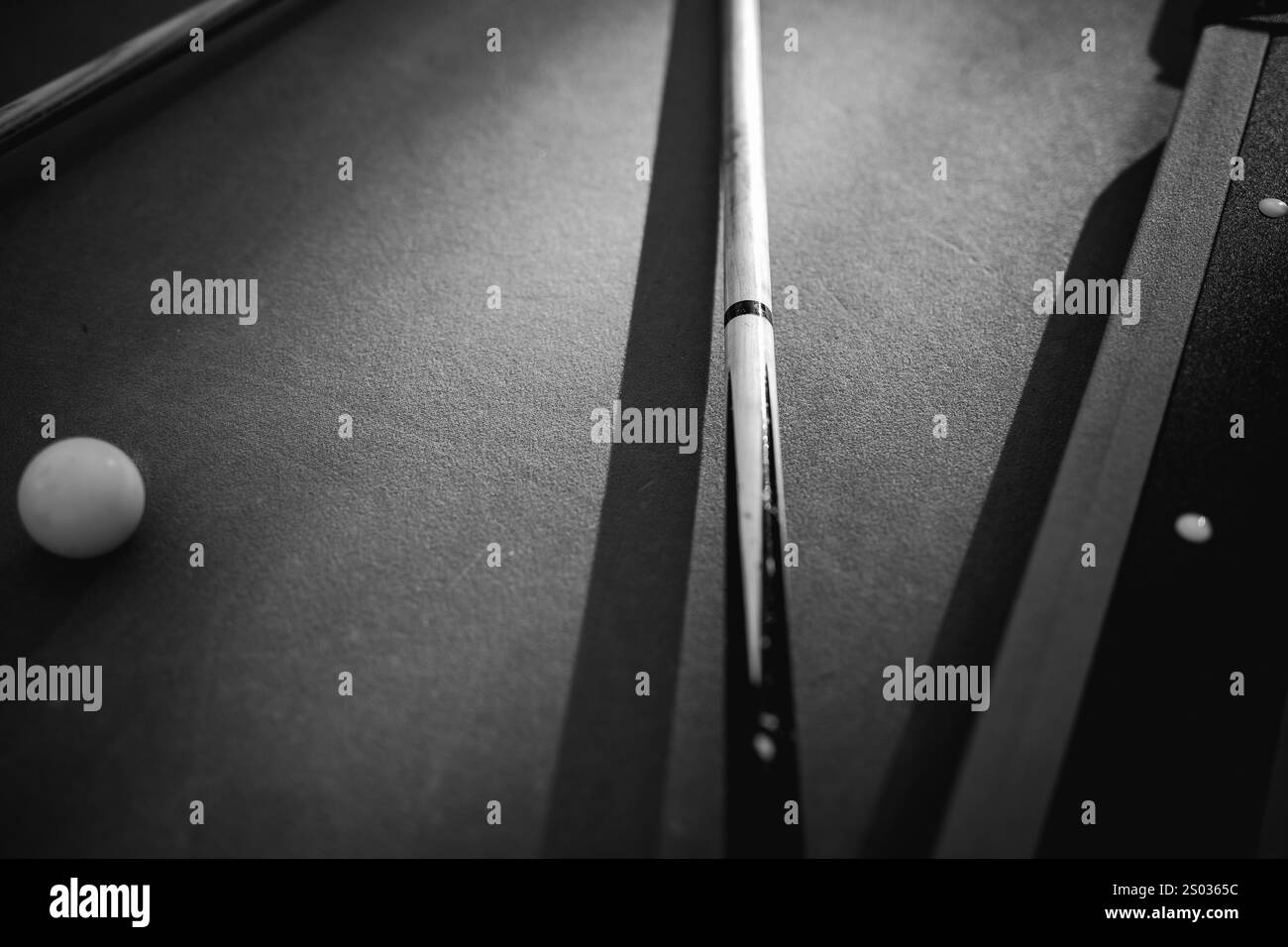 A pool table with scattered billiard balls, a cue stick, and ...