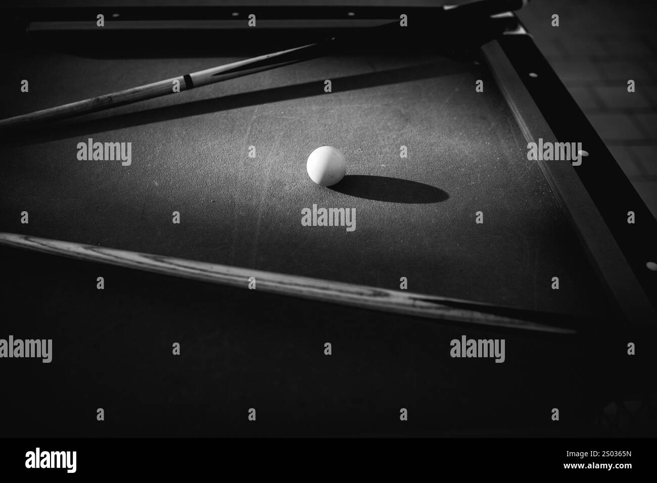 A pool table with scattered billiard balls, a cue stick, and ...
