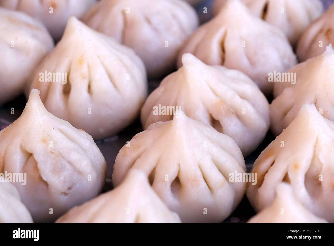 Woman making sweet rice modak stuffed with grated coconut and jaggery ...