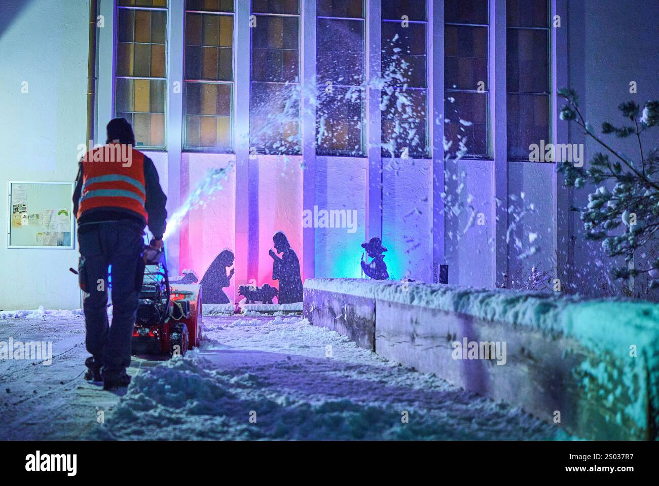 Marktoberdorf, Germany. 24th Dec, 2024. Man with a snow blower in front ...