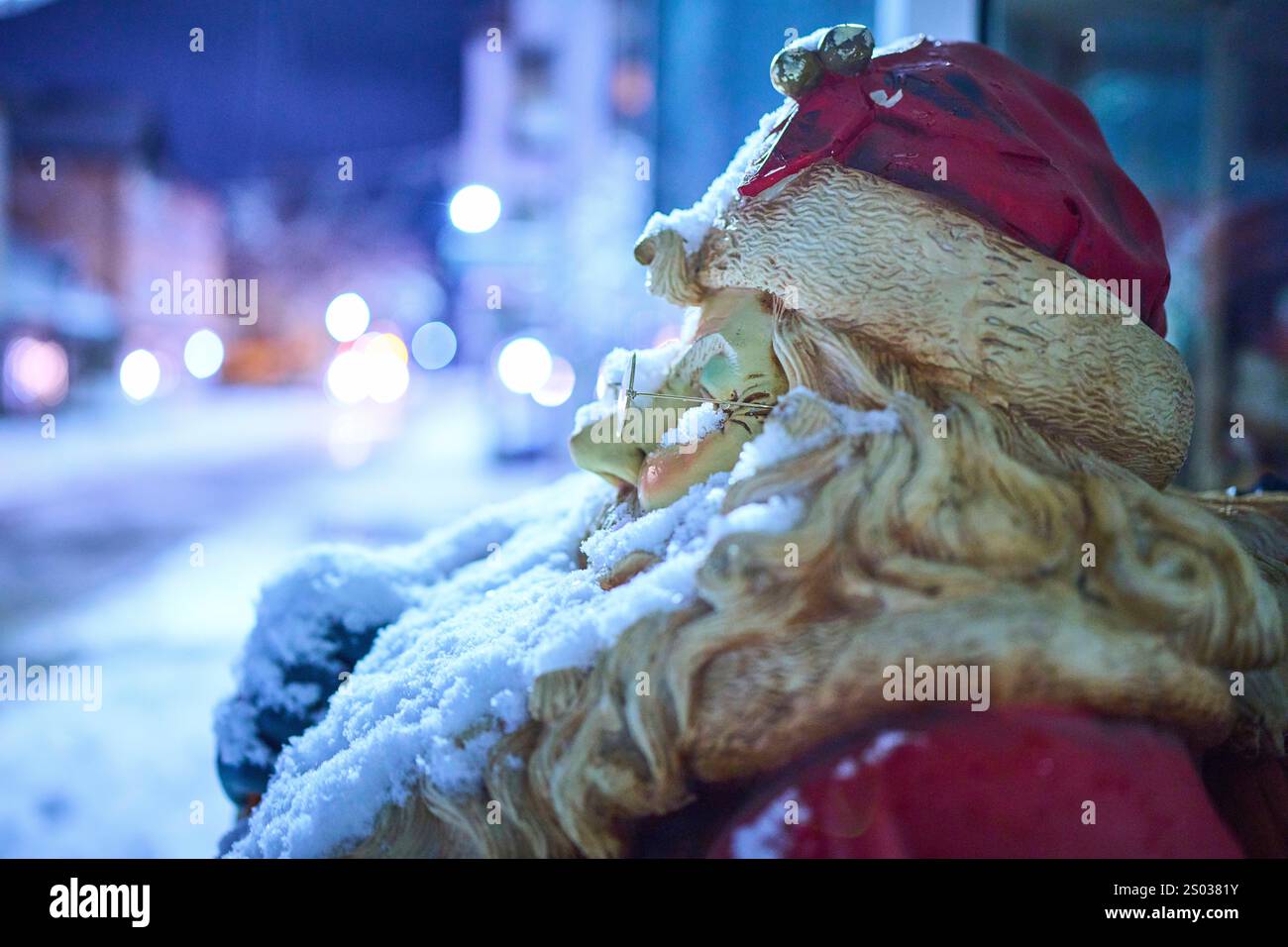 Santa Claus figure covered by snow and snow plows try to combat the ...