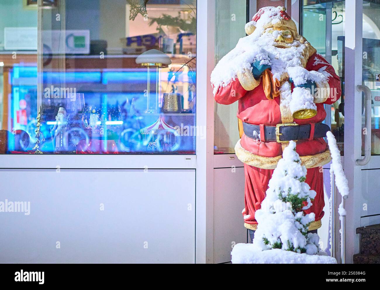 Santa Claus figure covered by snow and snow plows try to combat the ...
