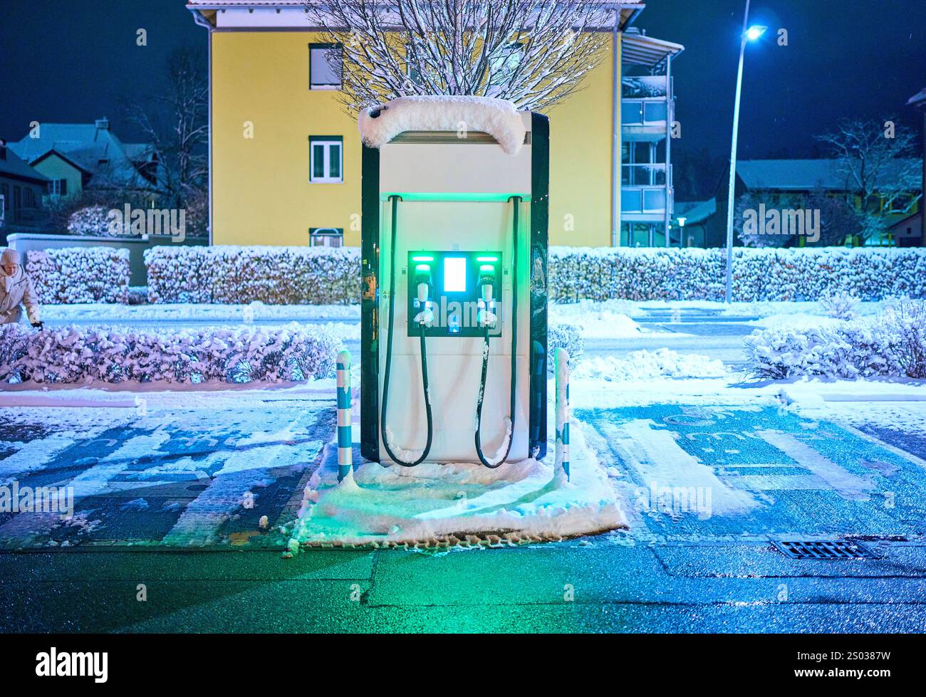 E-car charging station covered by snow and snow plows try to combat the ...