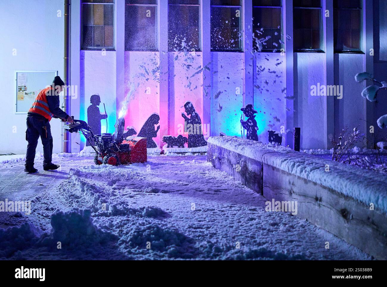 Man with a snow blower in front of a church with Maria and Joseph in ...