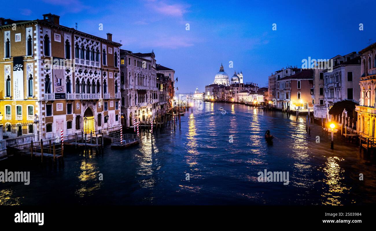 A scenic view of the Grand Canal in Venice at dusk, with illuminated ...