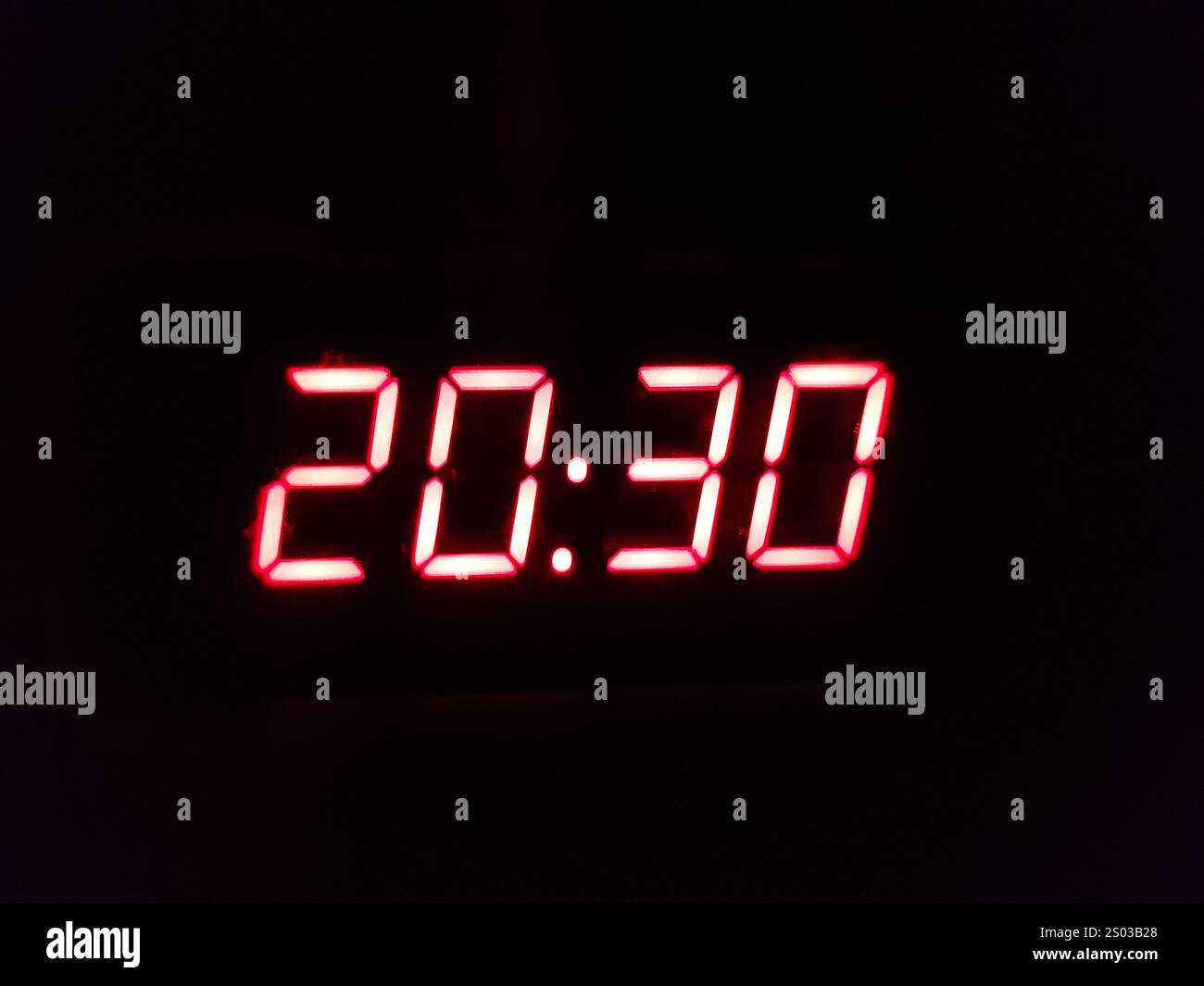 A digital clock face showing the time in red numbers on a black ...