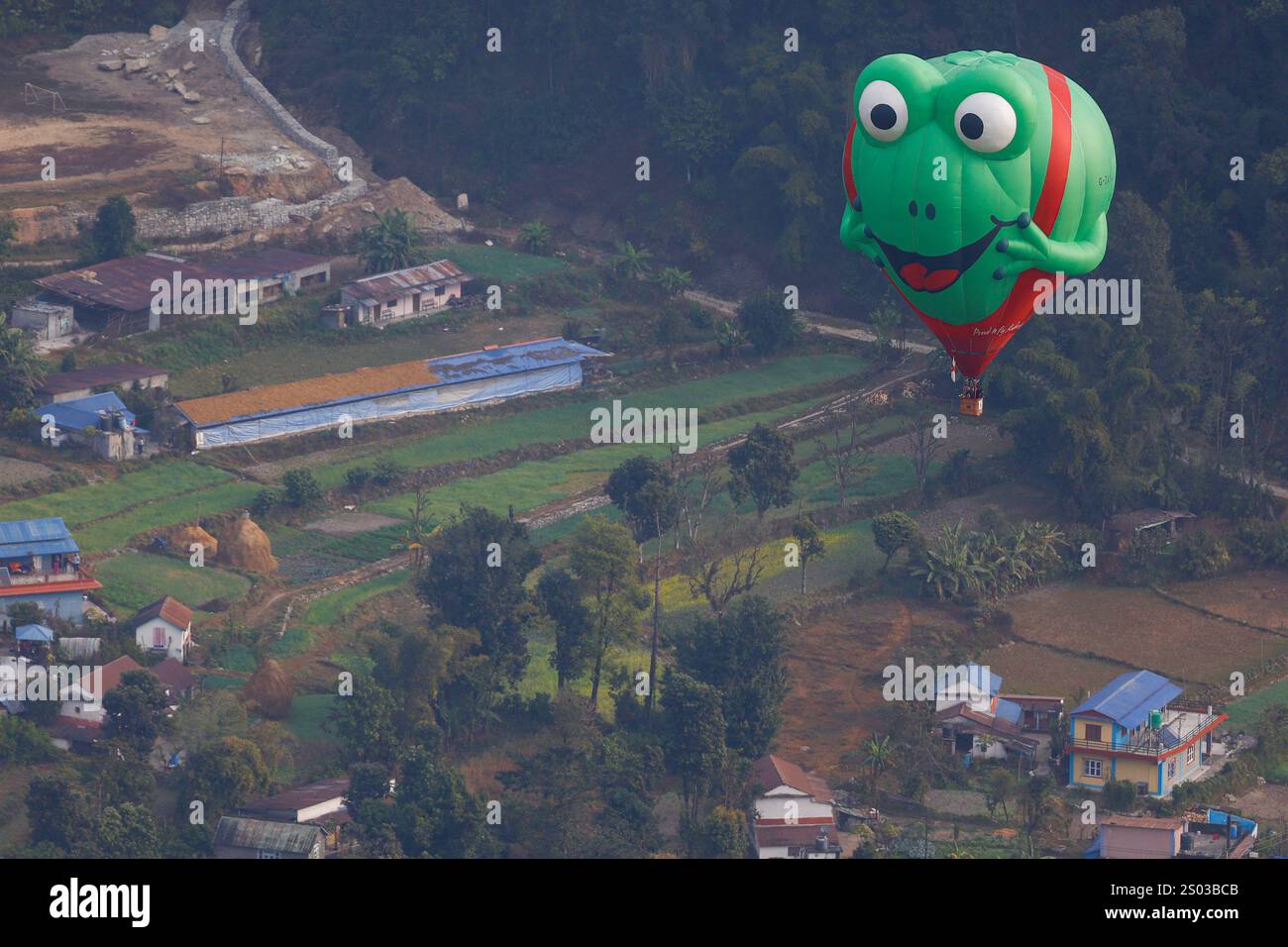Pokhara, Nepal. 24th Dec, 2024. A hot air balloon soars above Pame on ...