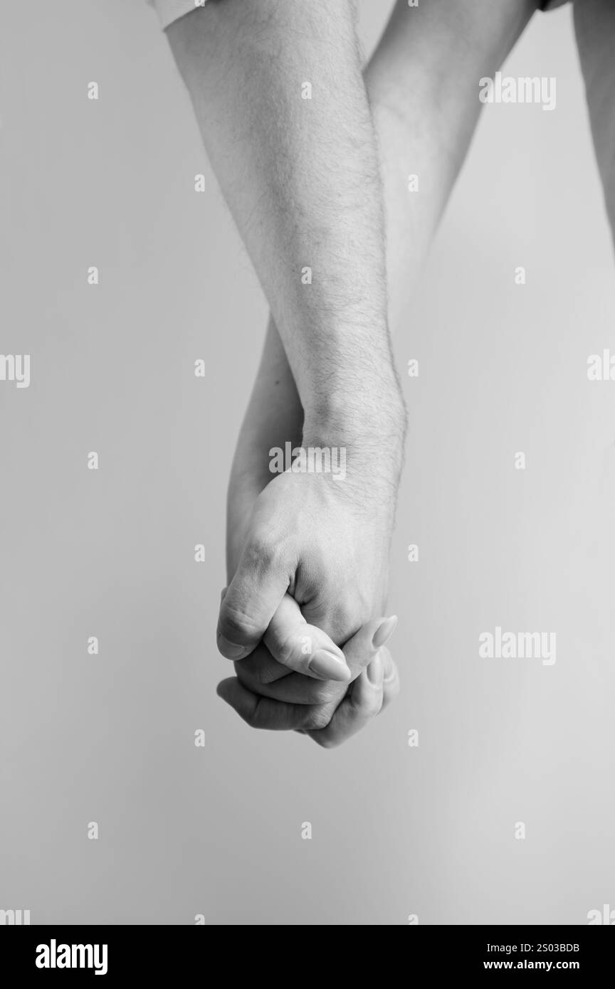 Two hands held together in grasp against neutral background. Close up ...