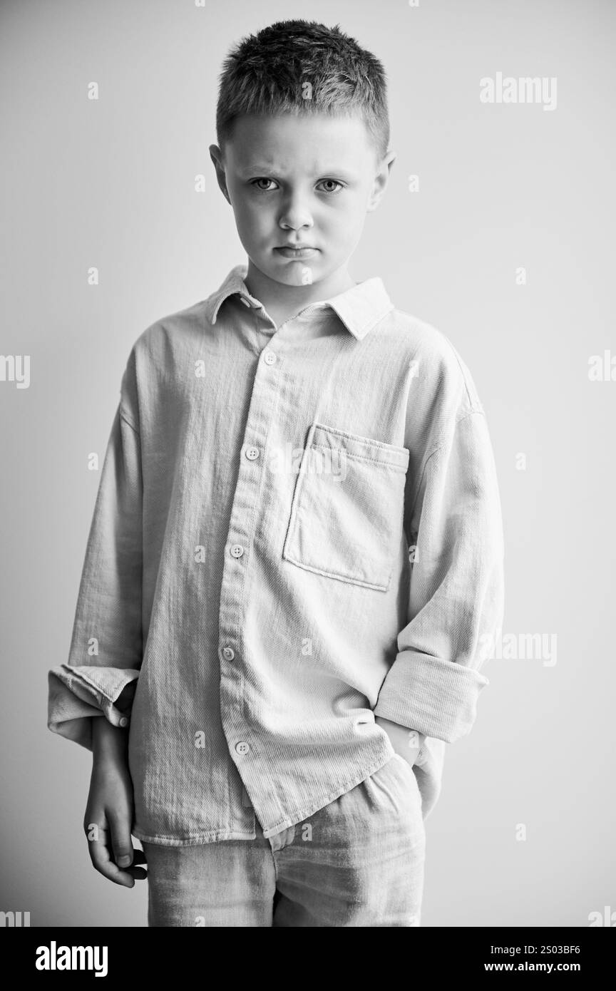 Portrait of young sad boy keeping hand in pocket, looking to the camera ...