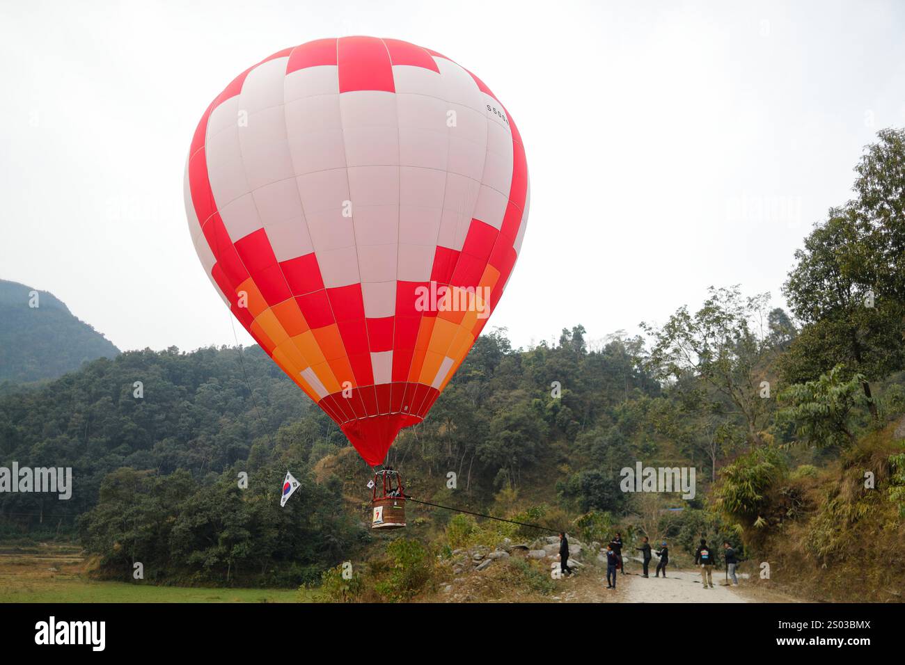 Pokhara, Nepal. 24th Dec, 2024. A hot air balloon prepares to land ...