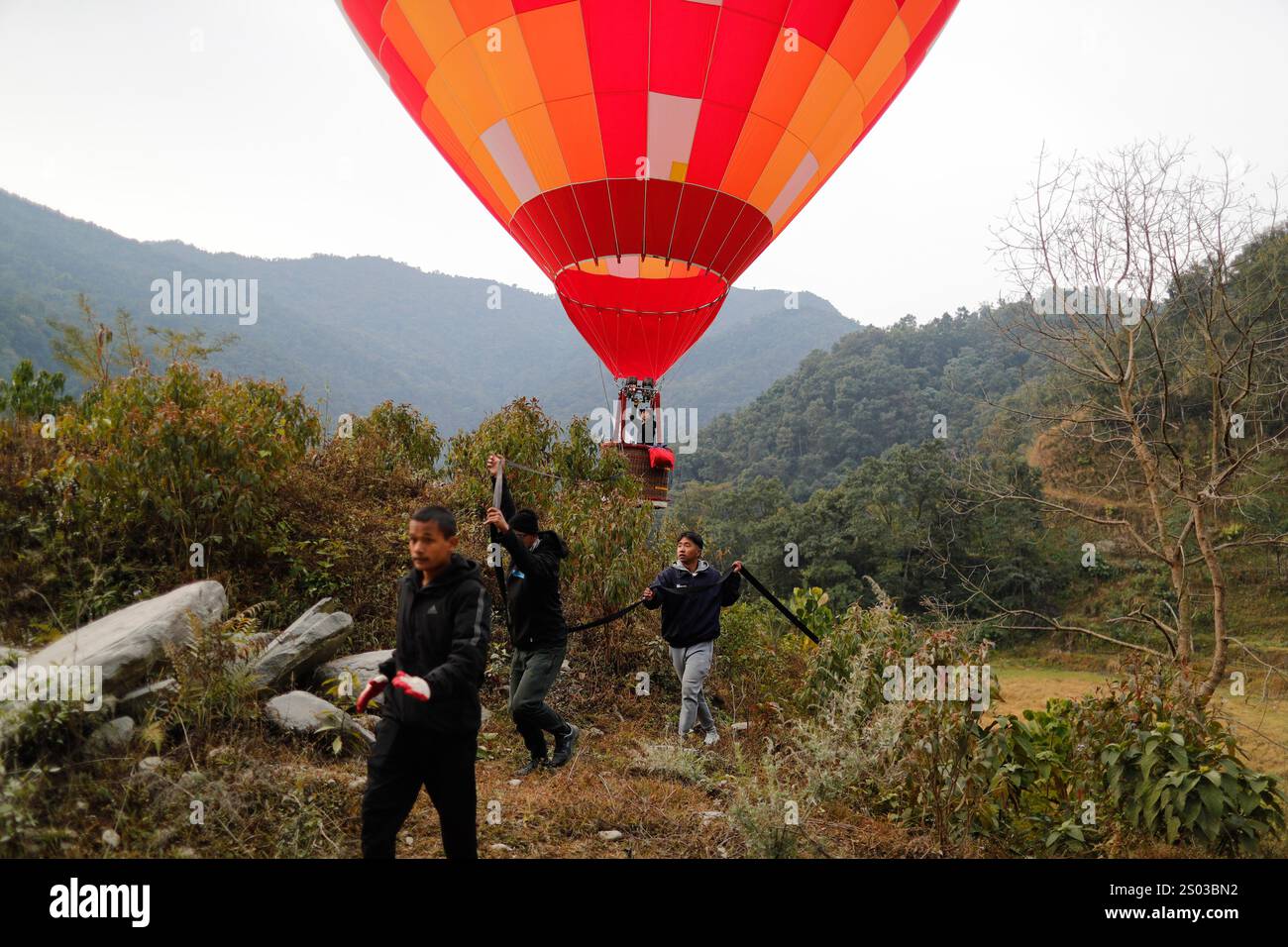 Pokhara, Nepal. 24th Dec, 2024. A hot air balloon prepares to land ...