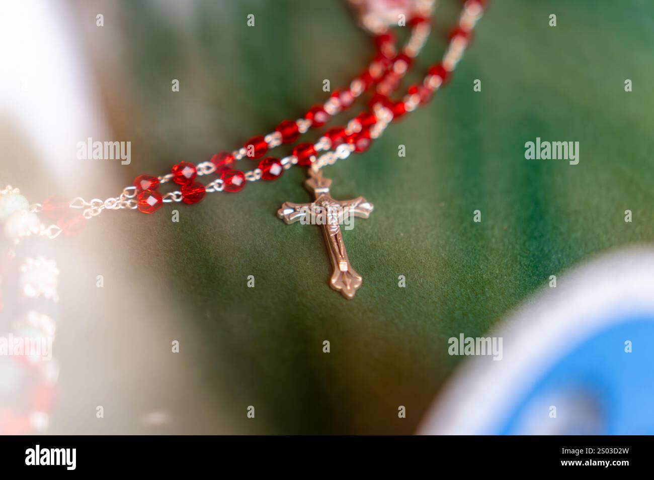 A red cross necklace with a silver cross pendant. The necklace is made ...