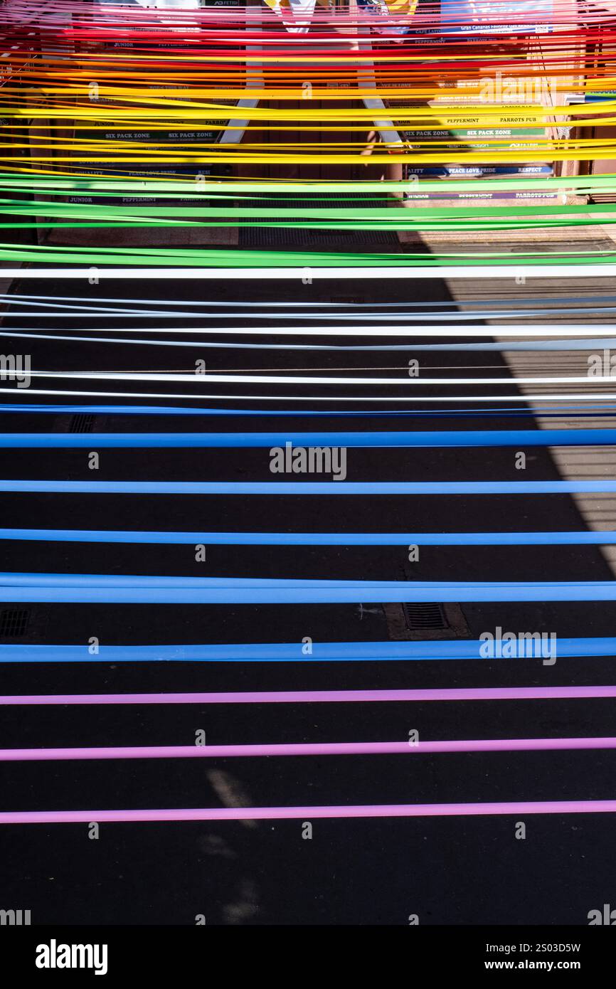 A colorful line of rainbow colored ribbons on a black surface. The ...