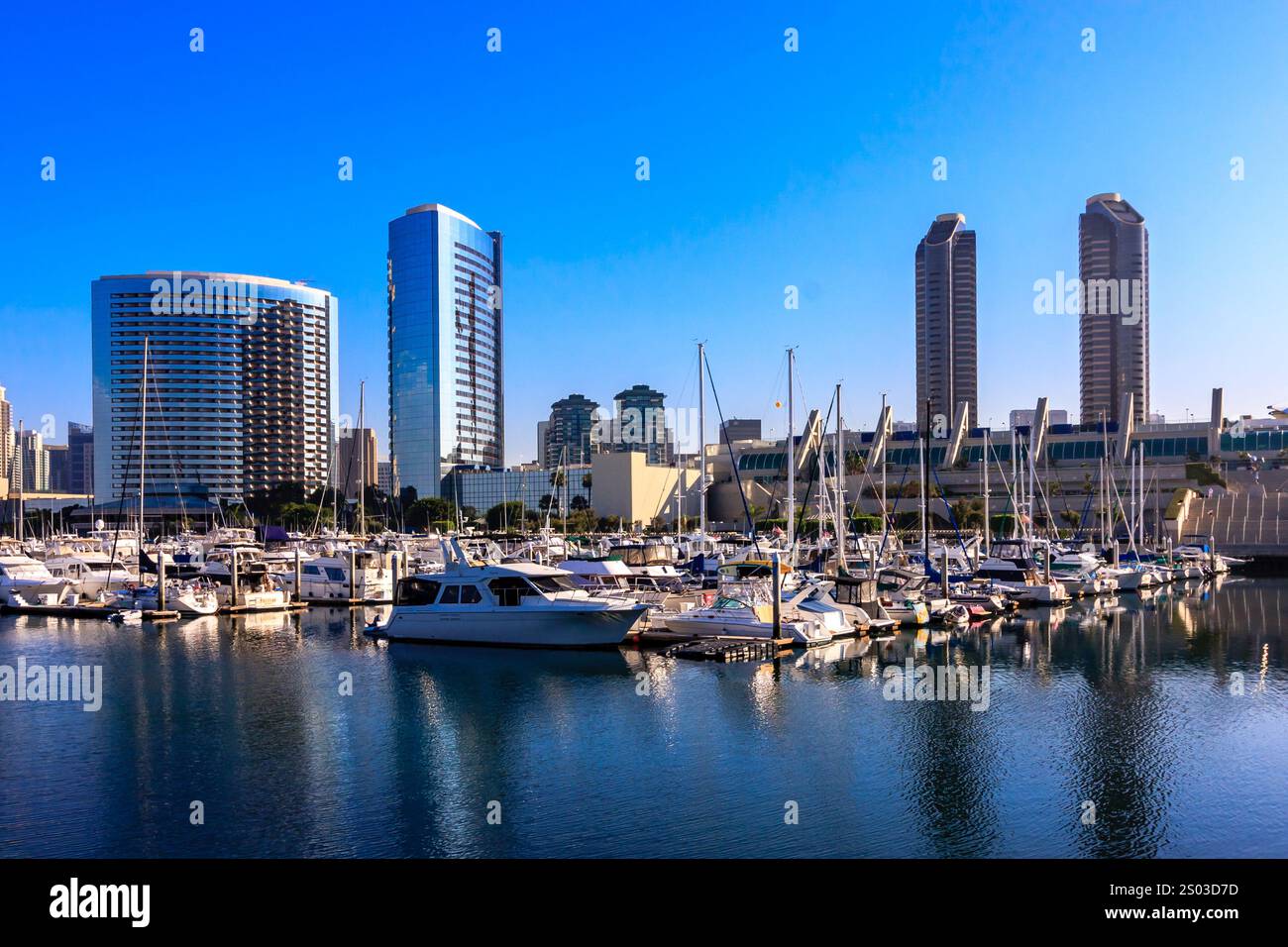 A large marina with many boats docked in the water. The water is calm ...