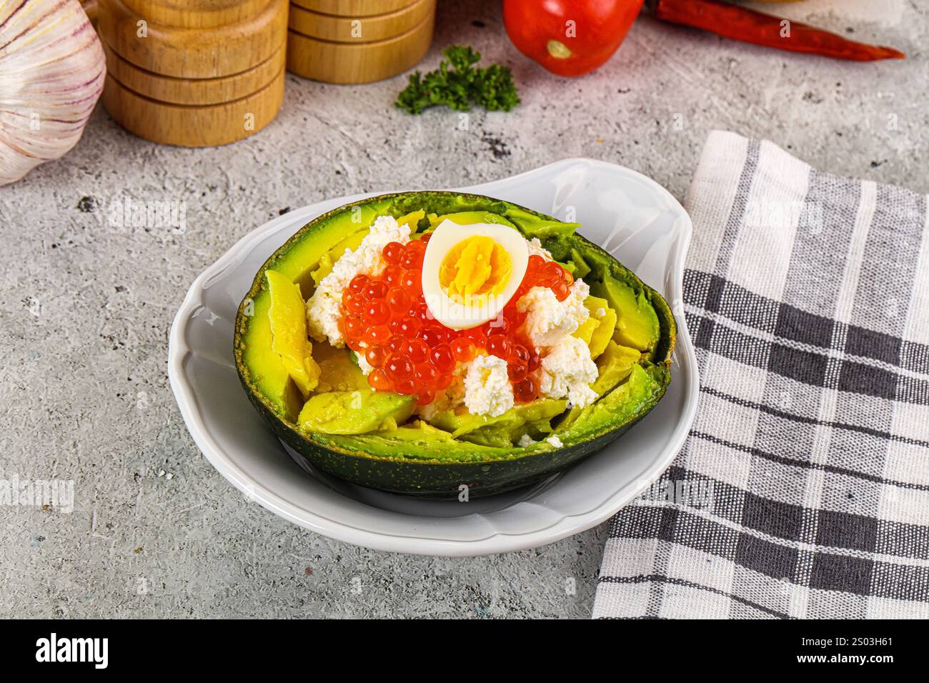 Avocado with red caviar and quil egg and soft cheese Stock Photo - Alamy