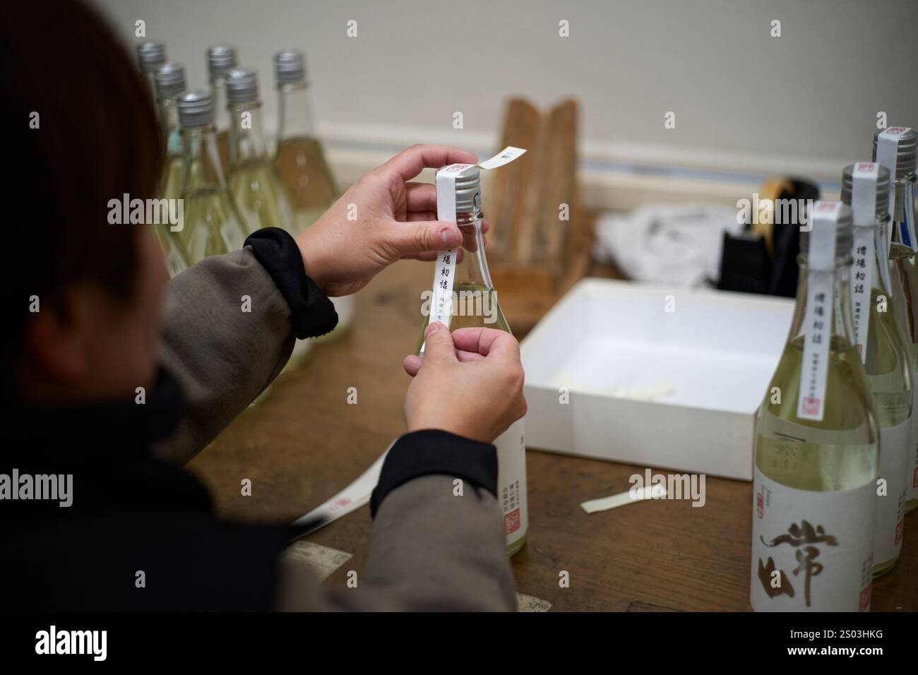 (241224) -- FUKUI, Dec. 24, 2024 (Xinhua) -- A worker seals a bottle of ...