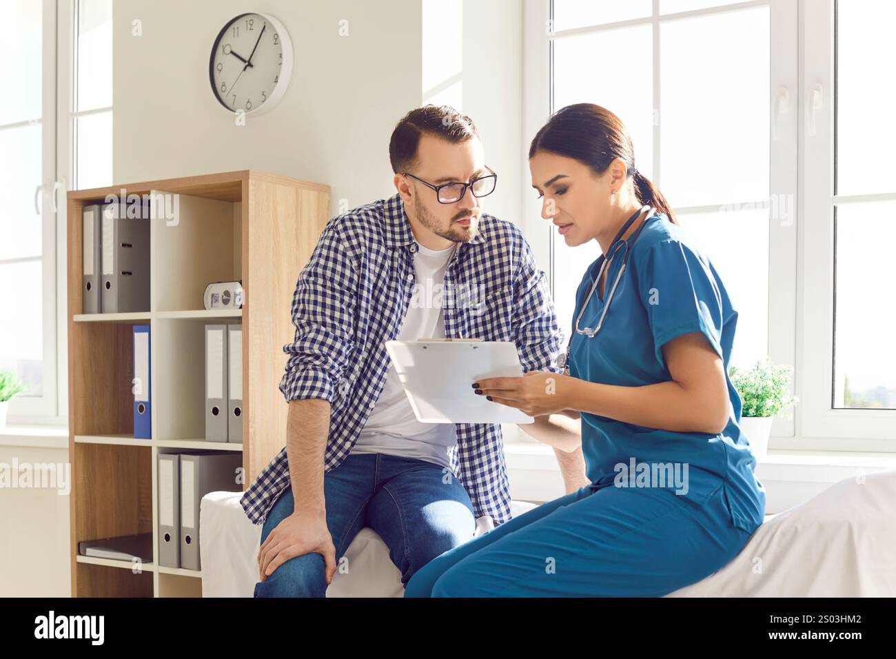 Young man patient visiting female nurse at doctors office during ...