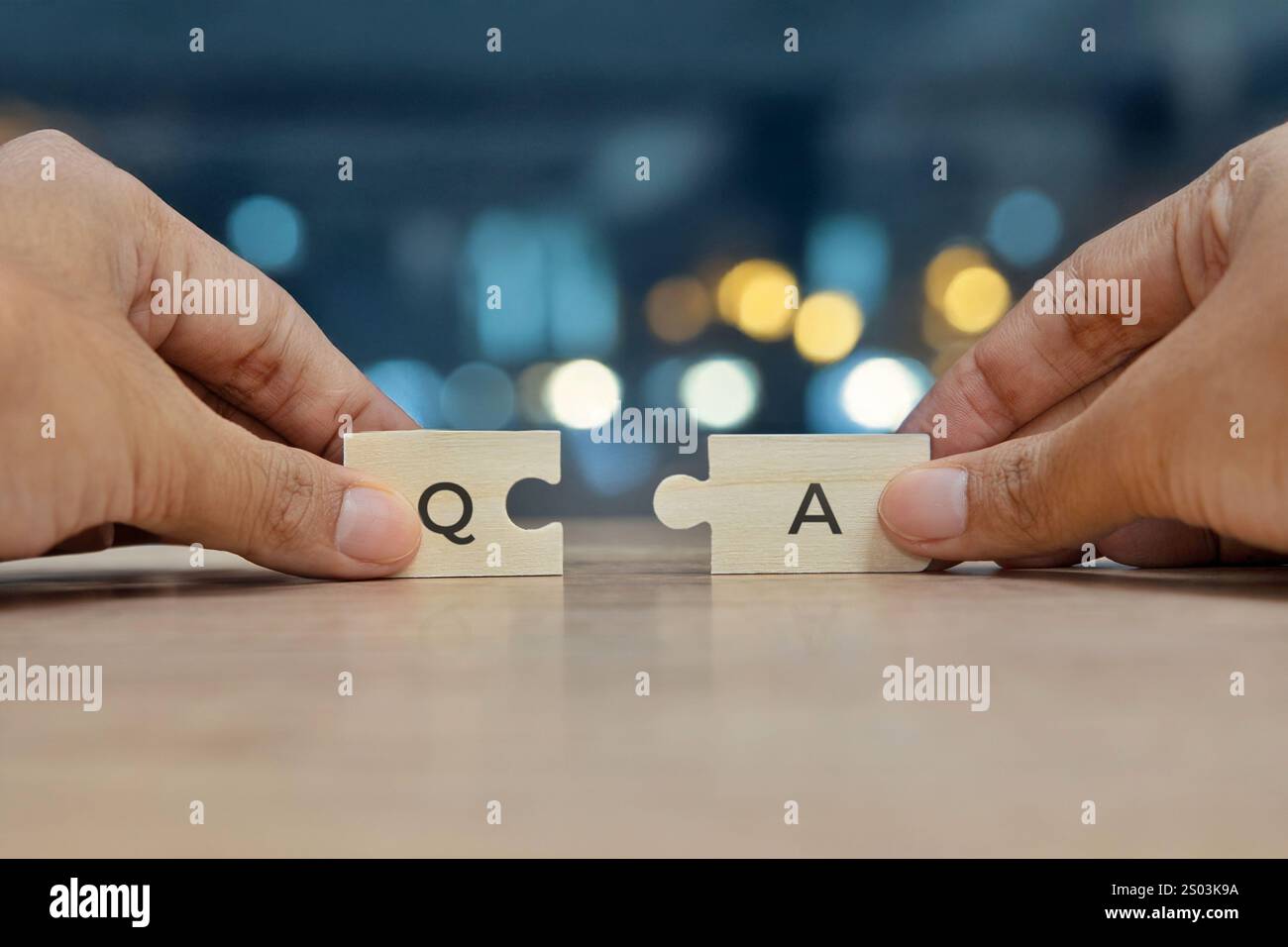 A close-up image of two hands holding puzzle pieces with the letters "Q" and "A". Question and ...