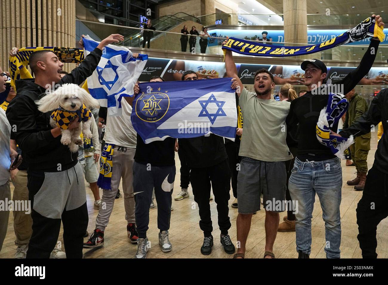 FILE - People welcome Maccabi Tel Aviv soccer fans as they arrive at ...