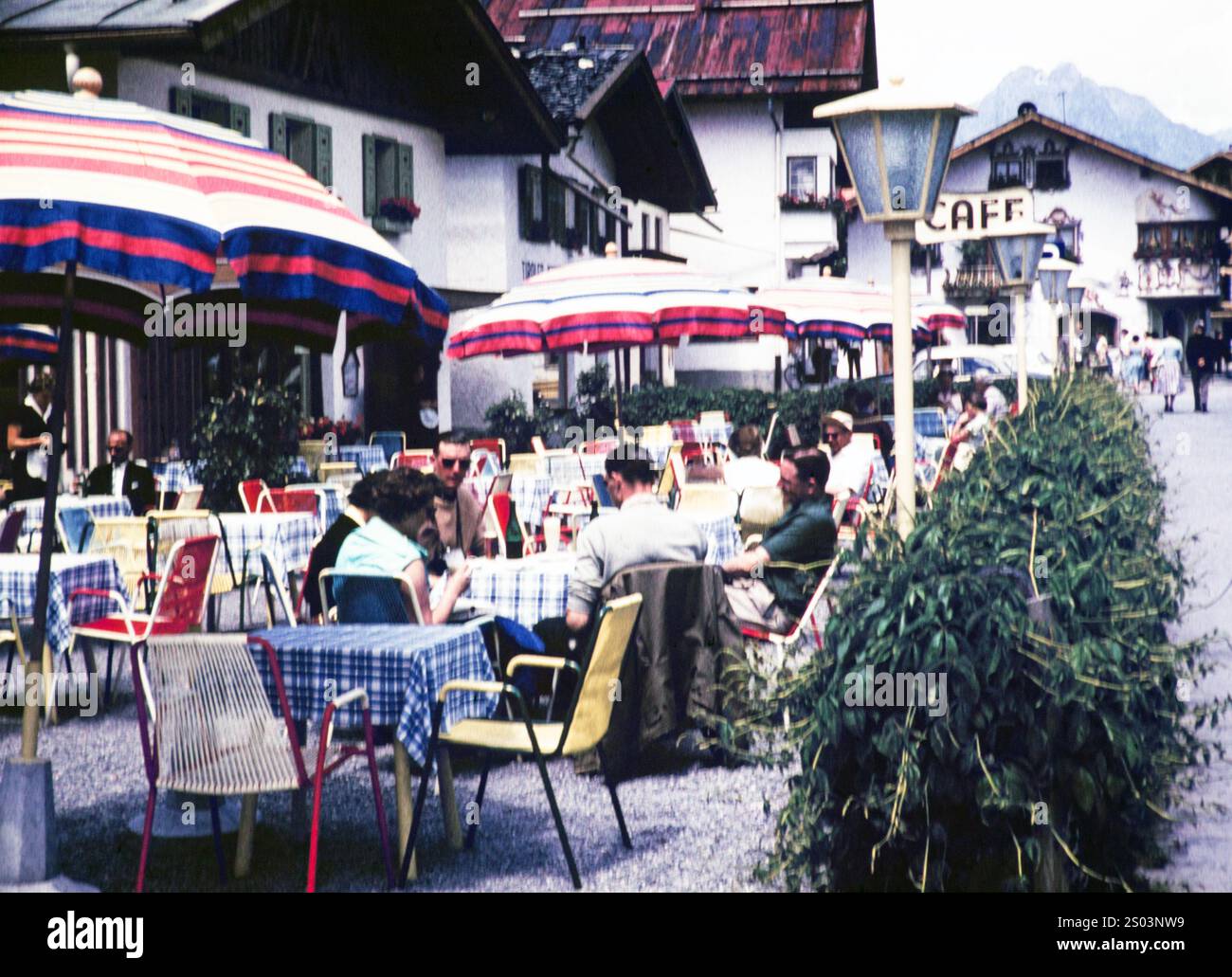 People sitting at outside tables of cafe in village of Seefeld, state ...