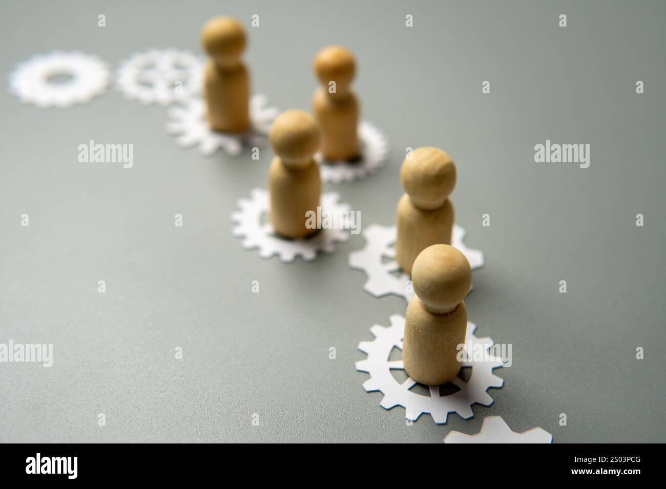 A Conceptual Image With Wooden Figures Standing On Interconnected Gears Teamwork Collaboration