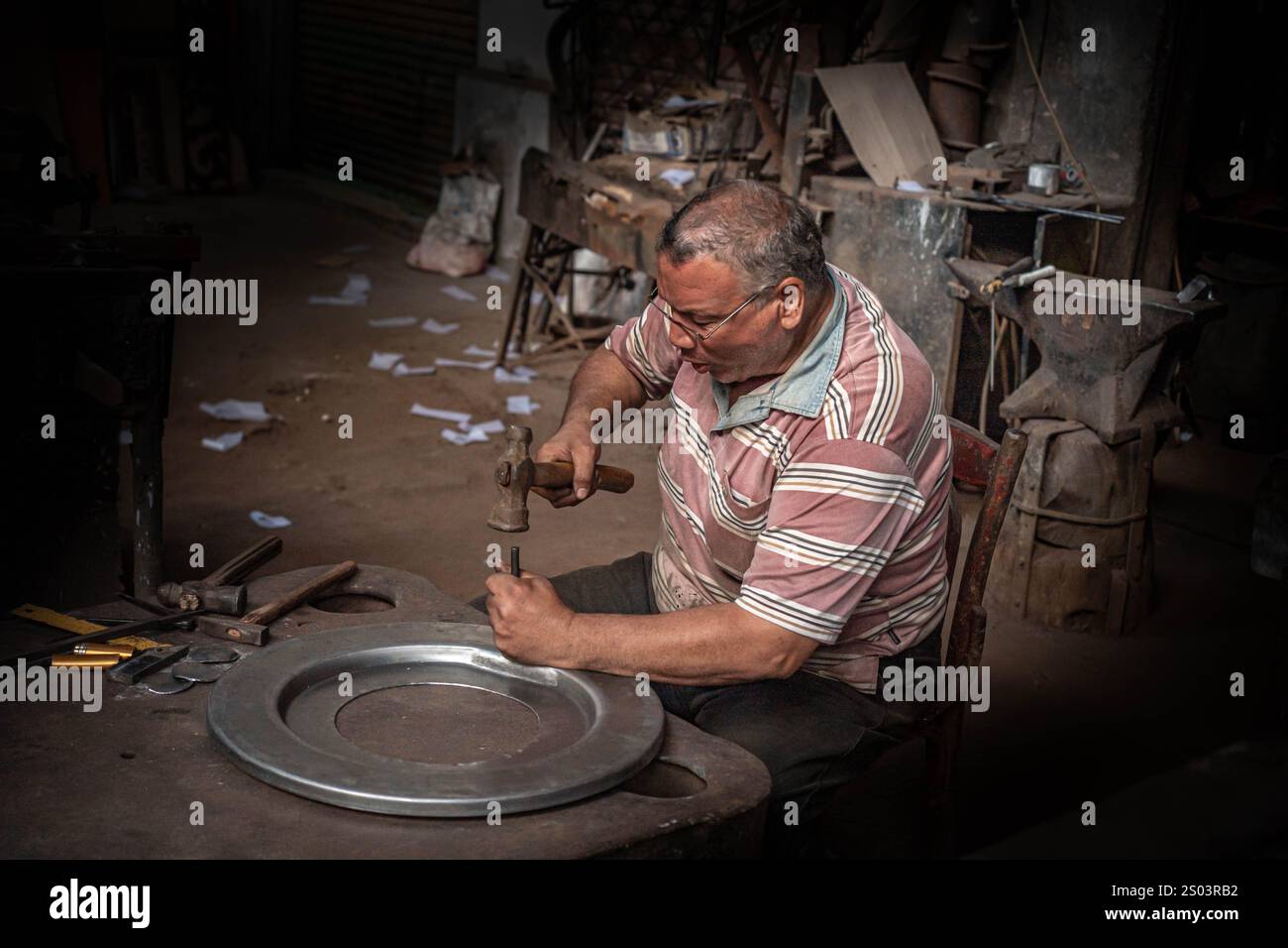 A craftsman in Alexandria, Egypt, working in a workshop, meticulously ...