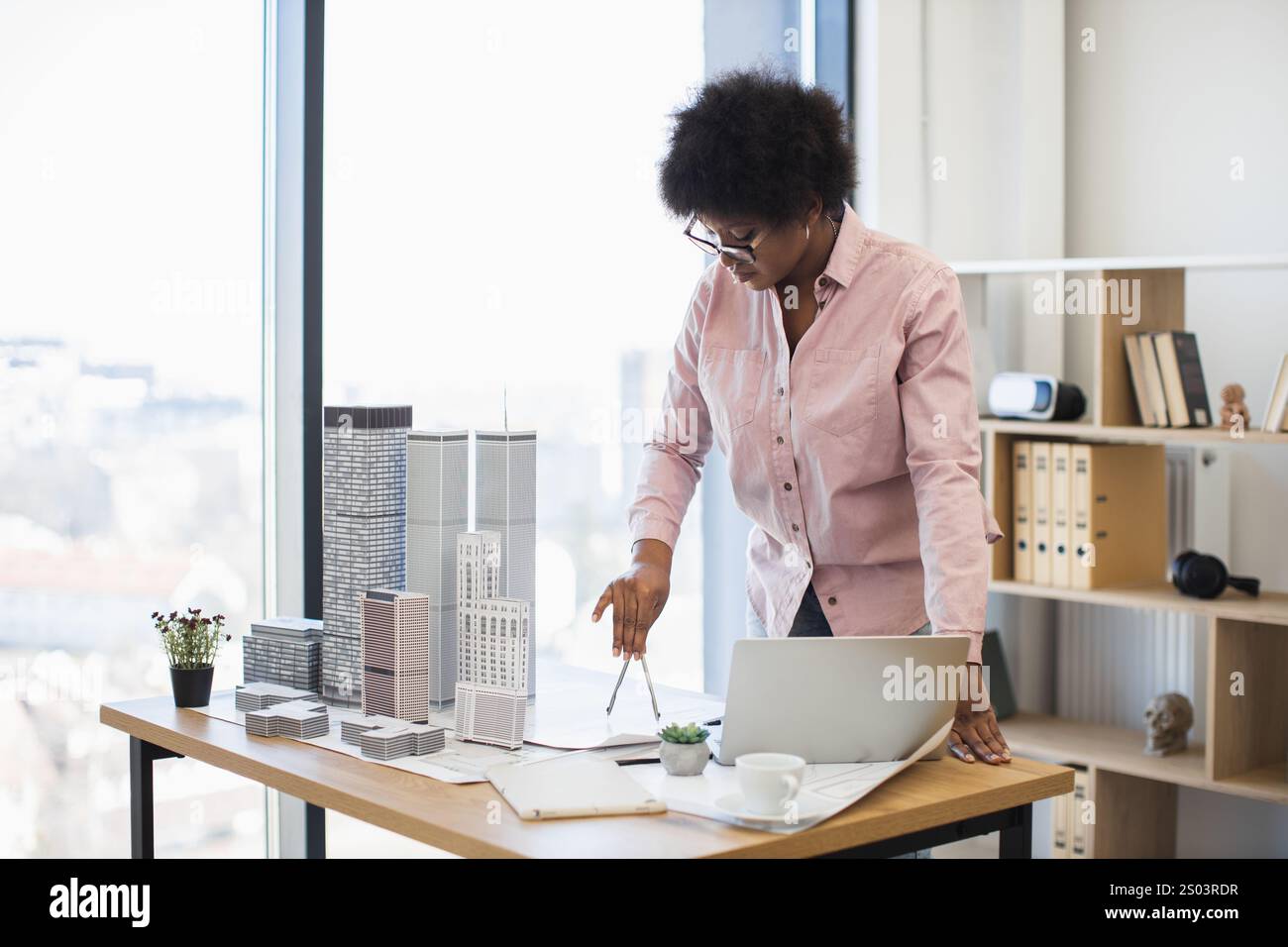 African American female architect works on modern city project using ...