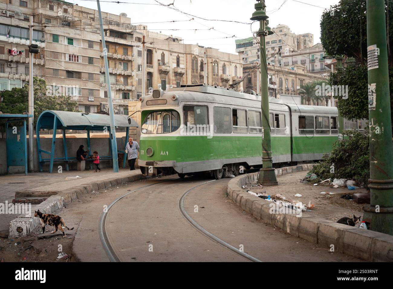 A historic green tram passes through a bustling street in Alexandria ...
