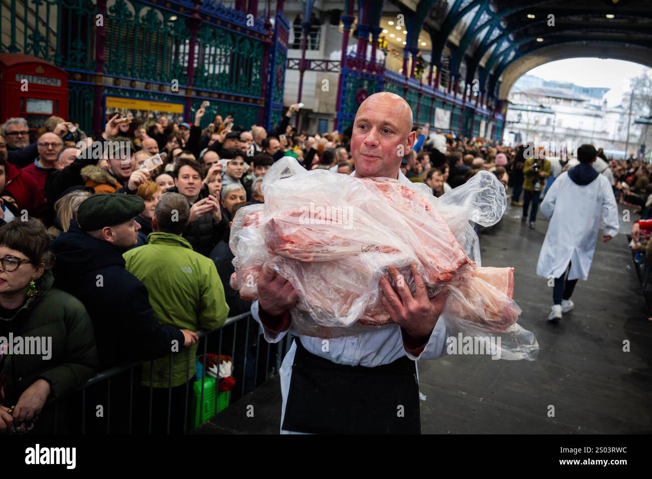 A butcher carries meat during the Smithfield Market Christmas meat ...