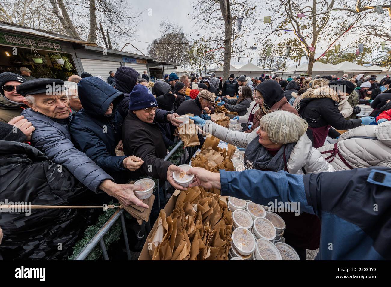 Split, Croatia. 24th Dec, 2024. Volunteers servers a free cod fish stew ...