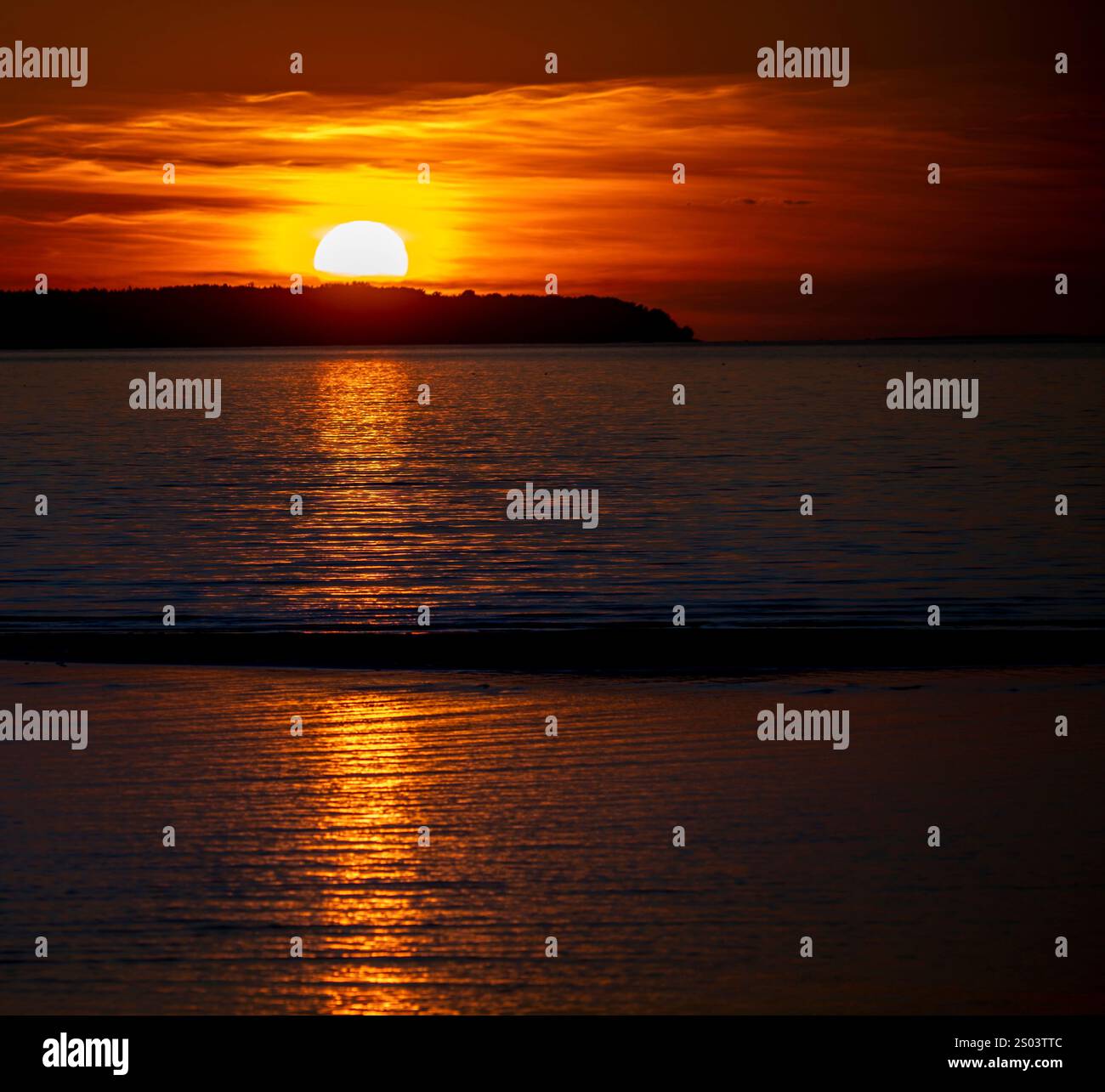 A stunning sunset over calm waters, with the sun dipping below the ...