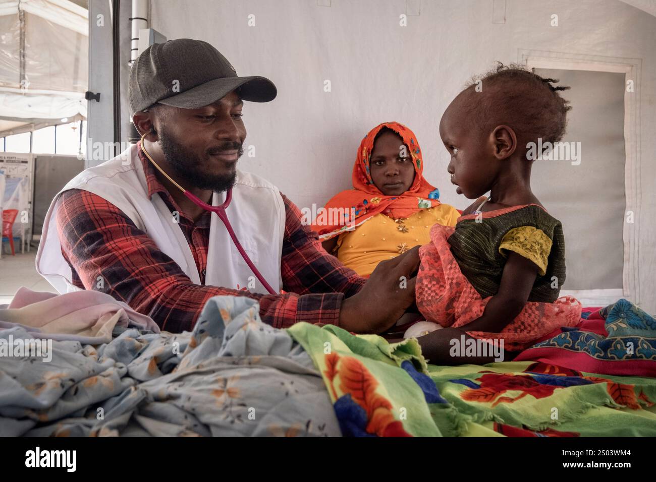FILE - A doctor treats a Sudanese child suffering from malnutrition are ...