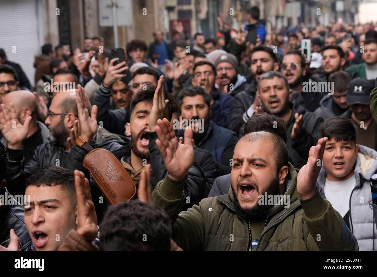 Syrian Christians shout slogans in Damascus, Syria, Tuesday, Dec. 24 ...