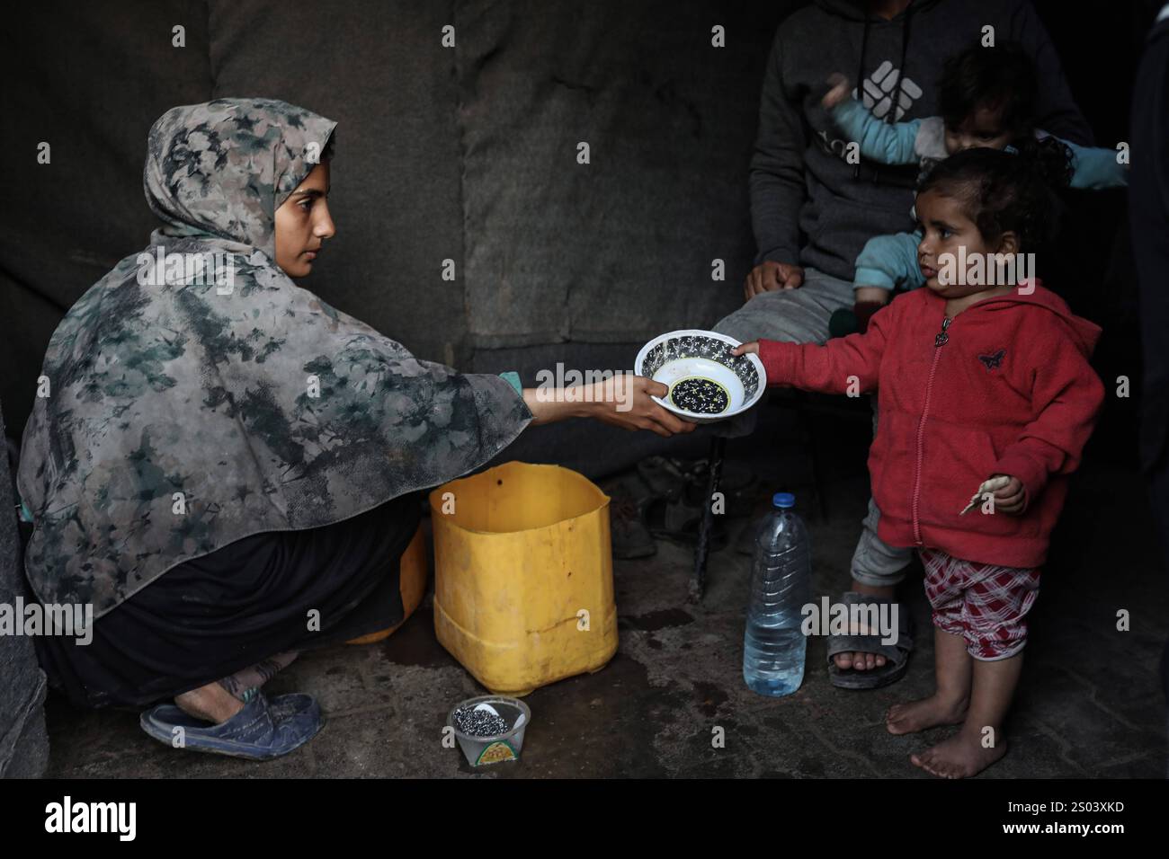 Palestinian displaced person Riyad Abu Sharkh, 26 years old, sits with his family inside his ...