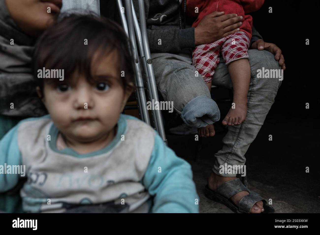 Palestinian displaced person Riyad Abu Sharkh, 26 years old, sits with ...