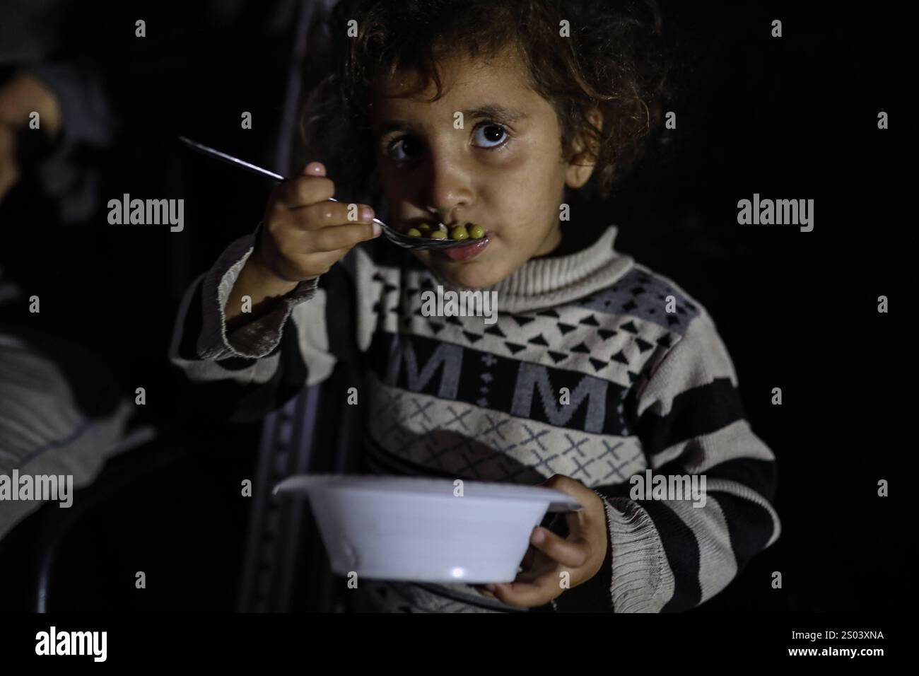 Palestinian displaced person Riyad Abu Sharkh, 26 years old, sits with ...