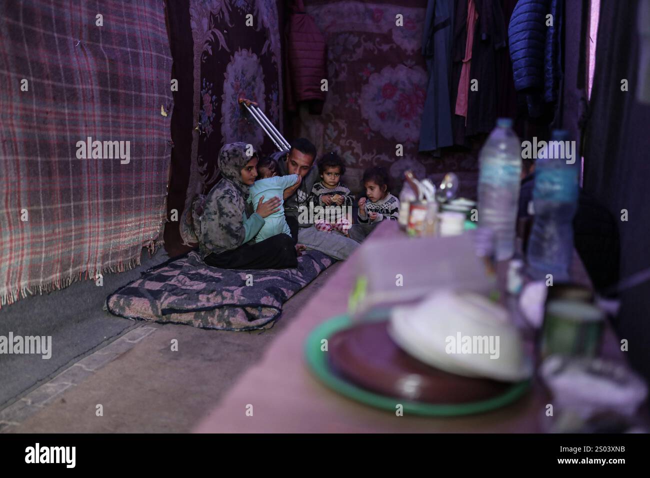 Palestinian displaced person Riyad Abu Sharkh, 26 years old, sits with ...