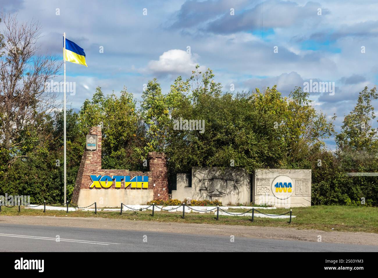 A large sign with the word "Kiev" on it is in front of a fence. The ...