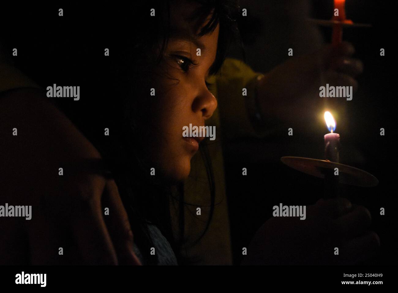 Bandung, West Java, Indonesia. 24th Dec, 2024. A child light a candle ...