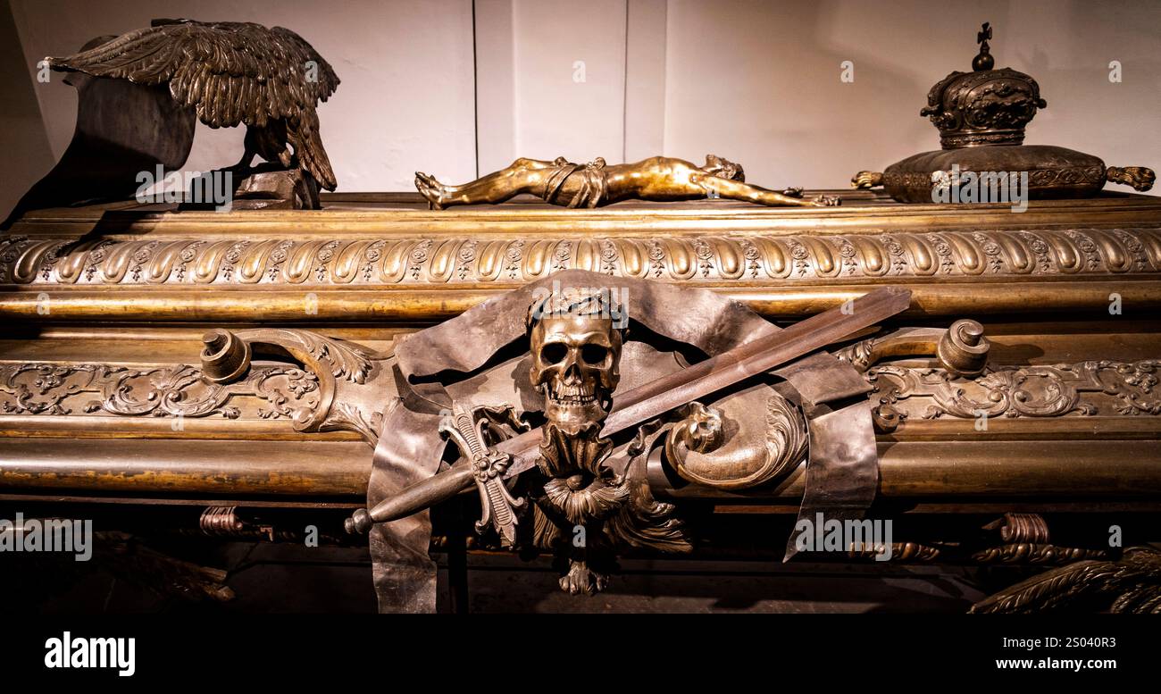 An ornate, metallic coffin adorned with a skull and sword. The setting ...