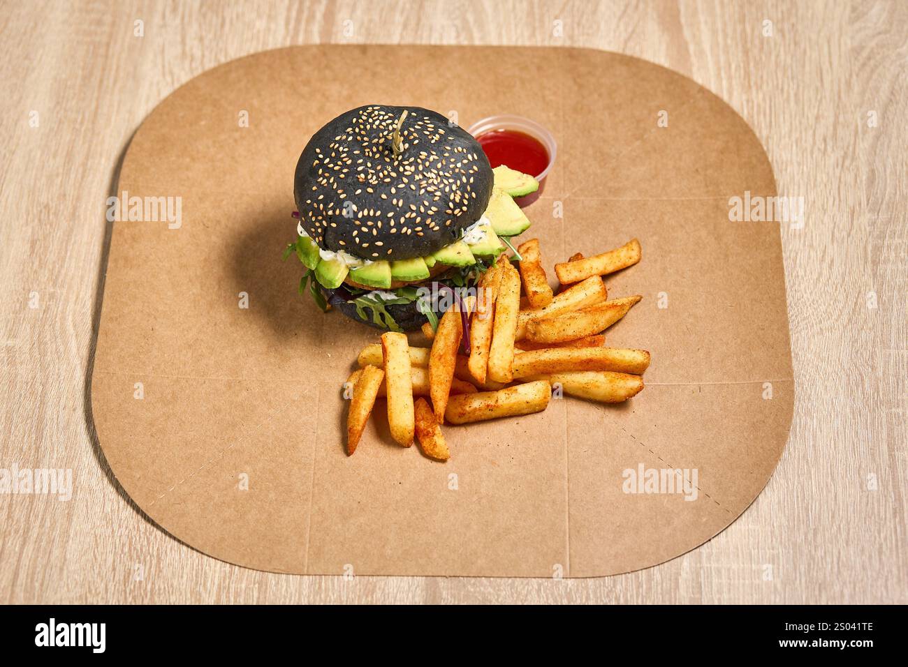 A unique black bun burger with fries and ketchup Stock Photo - Alamy