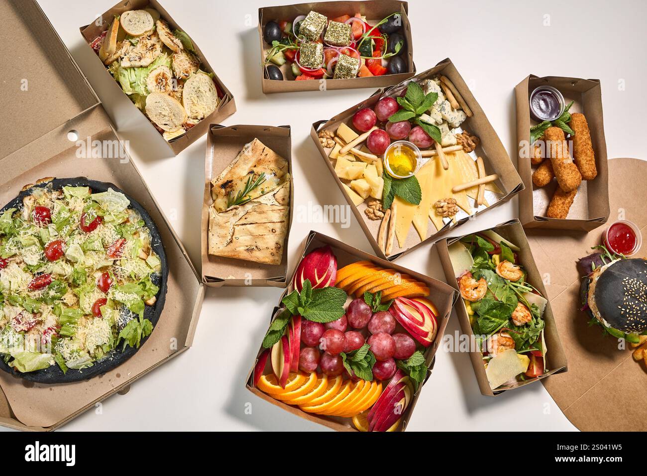 A collection of diverse takeaway meals in eco-friendly cardboard boxes ...